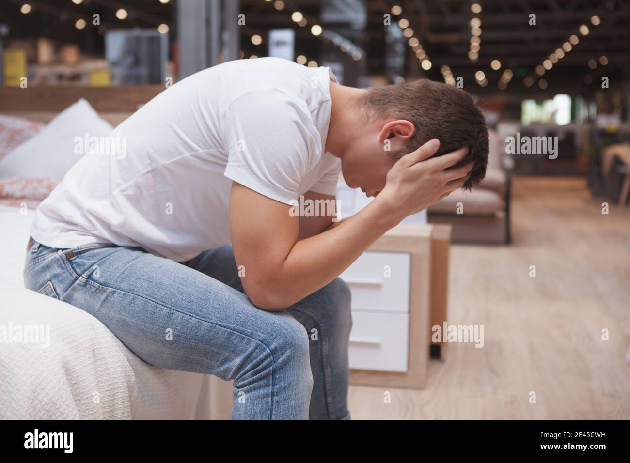 Man sitting in bed with hands on his face hi-res stock photography and ...