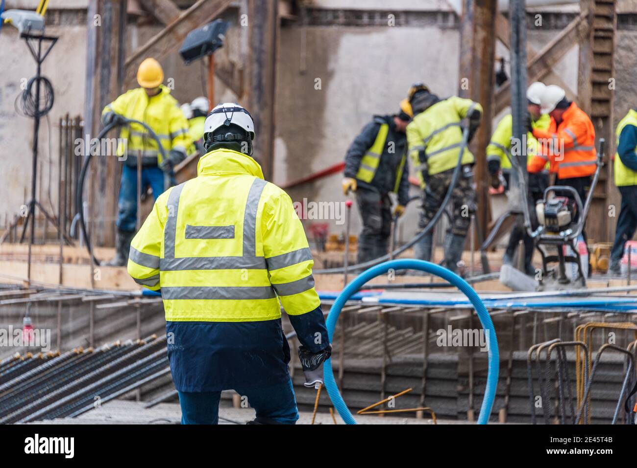 A group of construction workers during concrete casting work, using ...