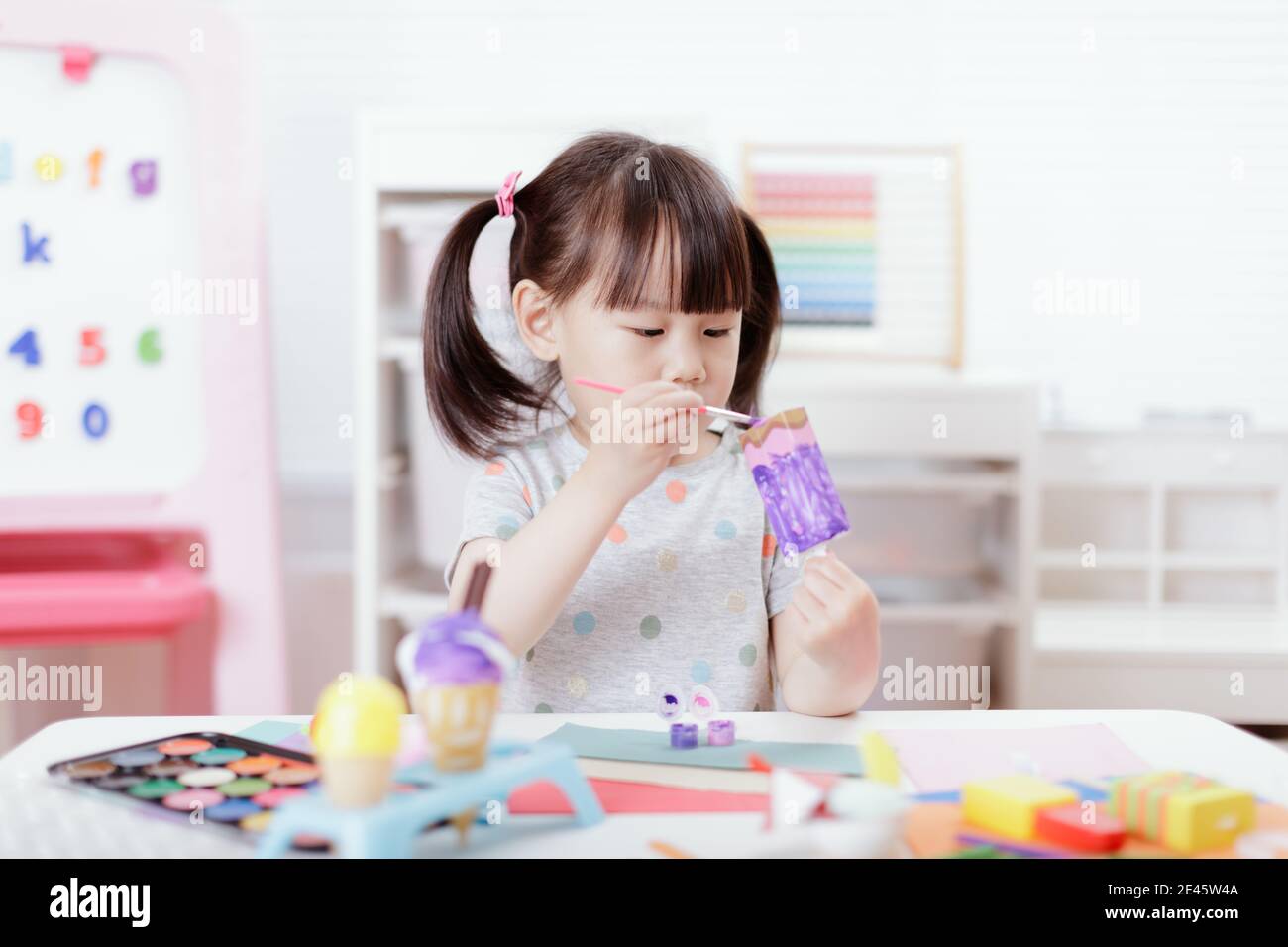 young girl decorating hand made craft for homeschooling Stock Photo - Alamy