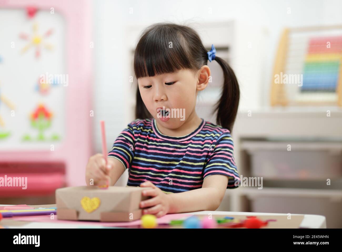 young girl decorating hand made craft for homeschooling Stock Photo - Alamy