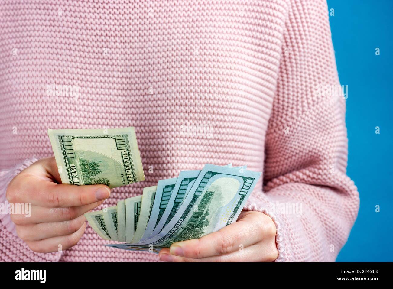 The process of counting money. The girl is counting a bundle of dollars ...