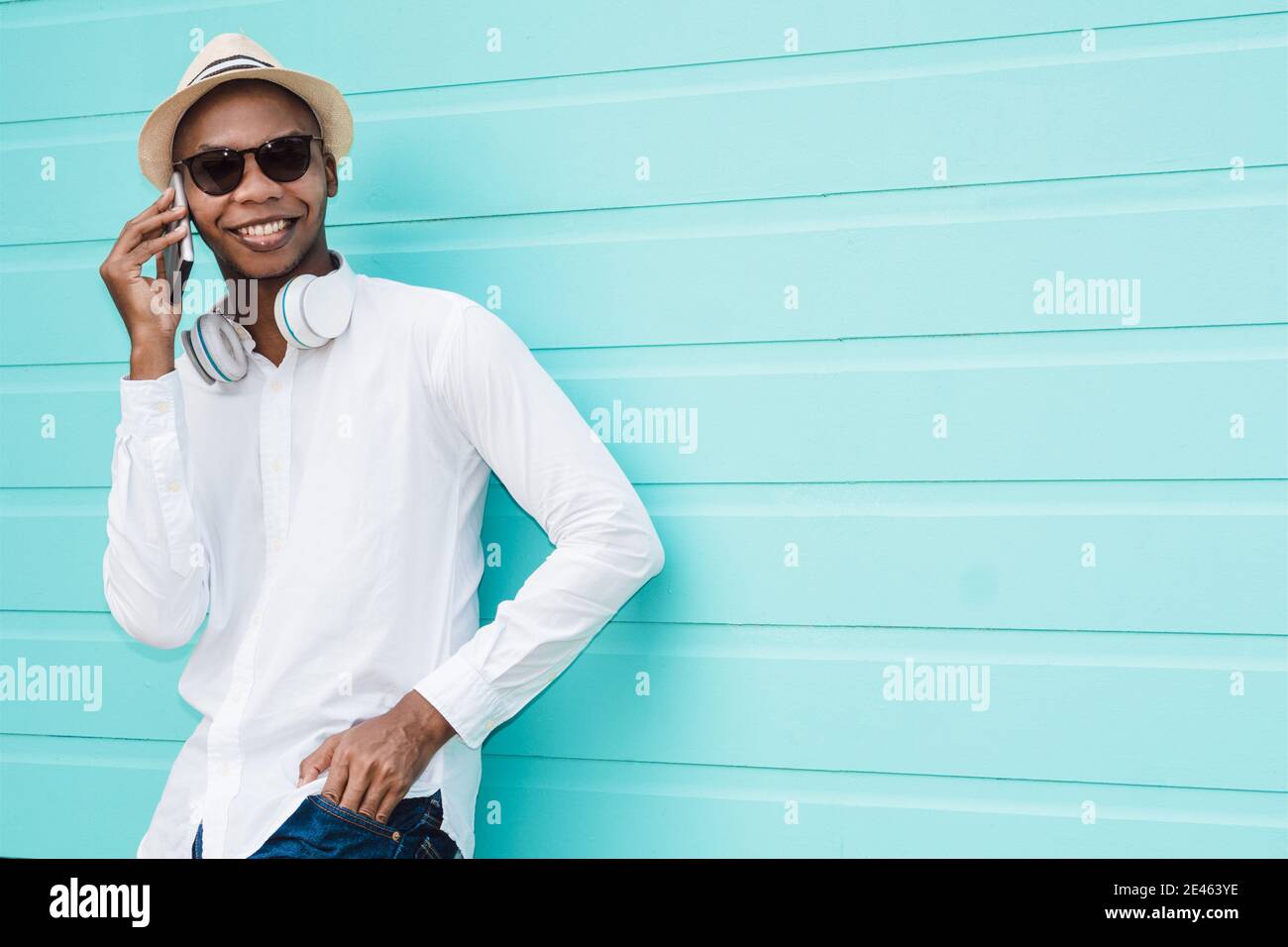 Cool Afro-American male calling someone over his phone against a light ...
