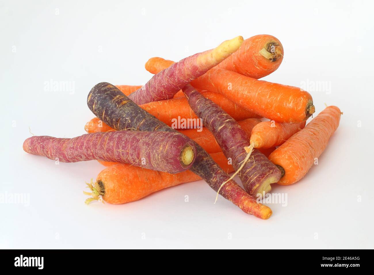 Black carrots and orange carrots over white background Stock Photo - Alamy