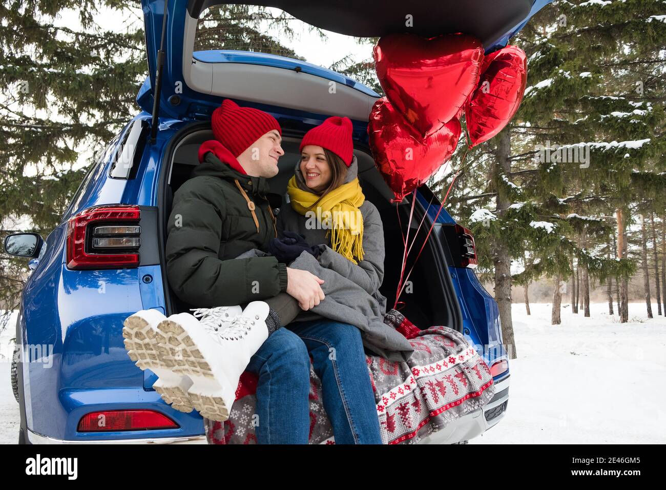 Romantic young hipster couple hugging while sitting in car trunk. Love ...