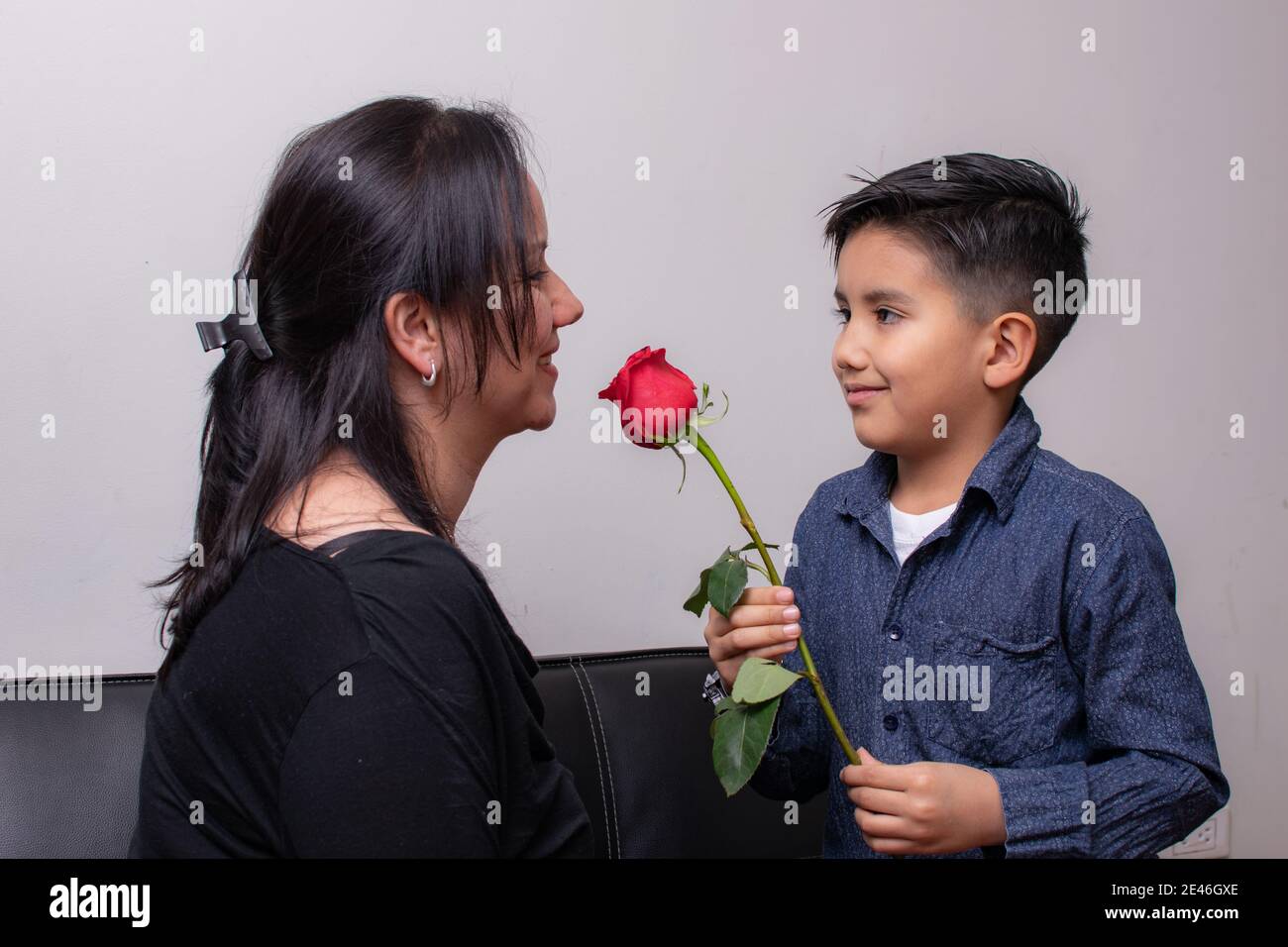 Closeup shot of son giving a rose to his beautiful mom on Mother's day ...