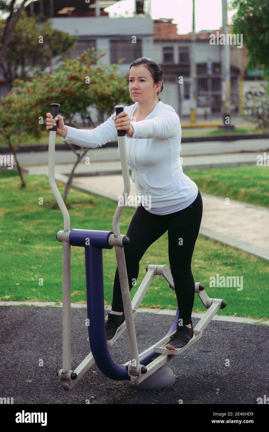 Vertical shot of a female exercising in the public park court with ...
