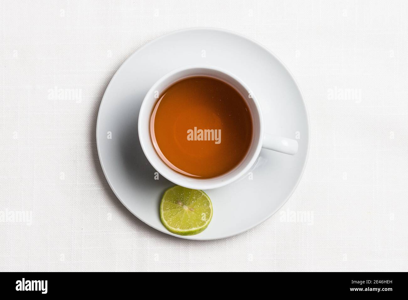Top view of a cup of lemon drink with a lemon slice on white background ...