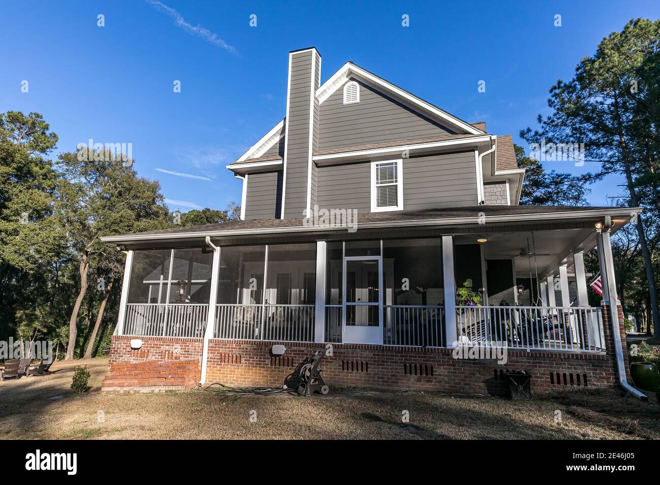 Side view of a large two story blue gray house with wood and vinyl ...