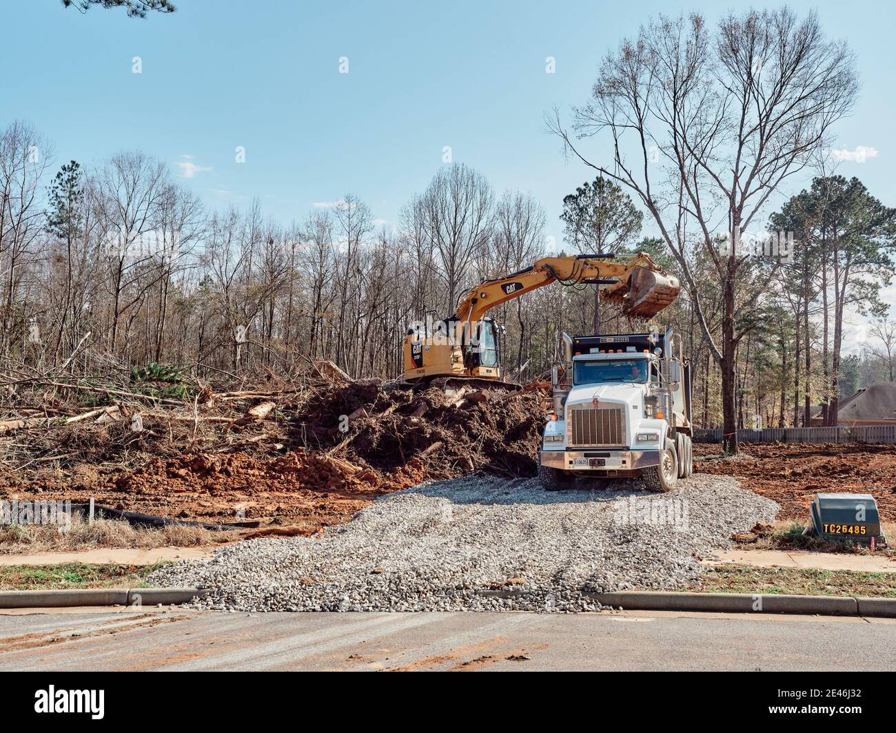 Digger or excavator and dump truck clearing land for new construction ...