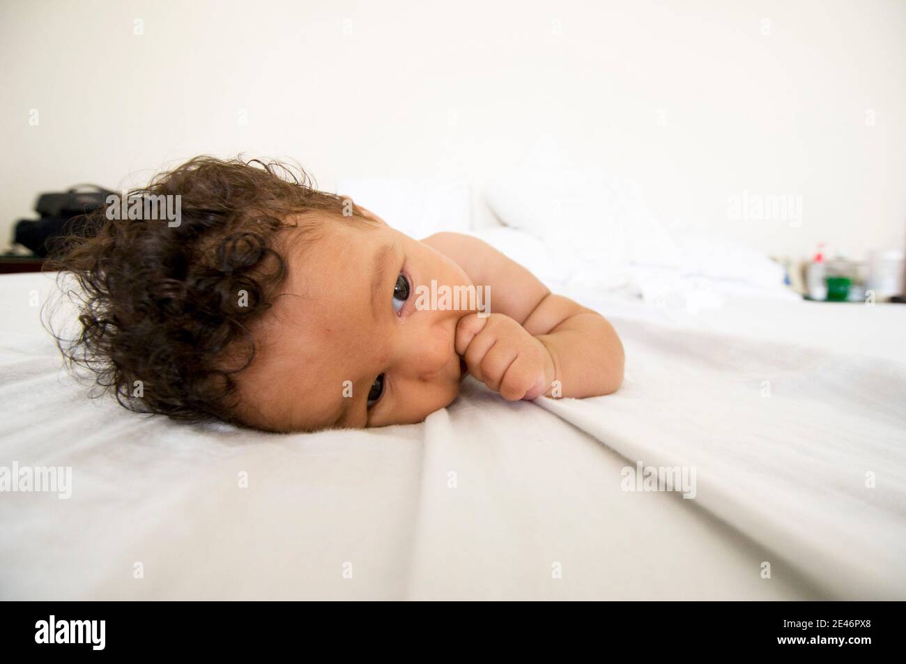 Infant falling asleep on the bed Stock Photo - Alamy