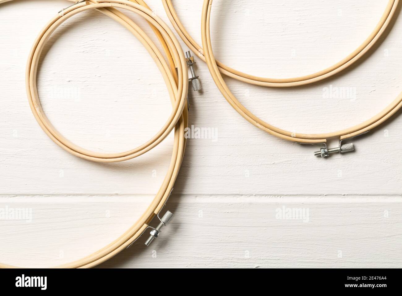 Set of round embroidery or stitching frames on white wooden table ...