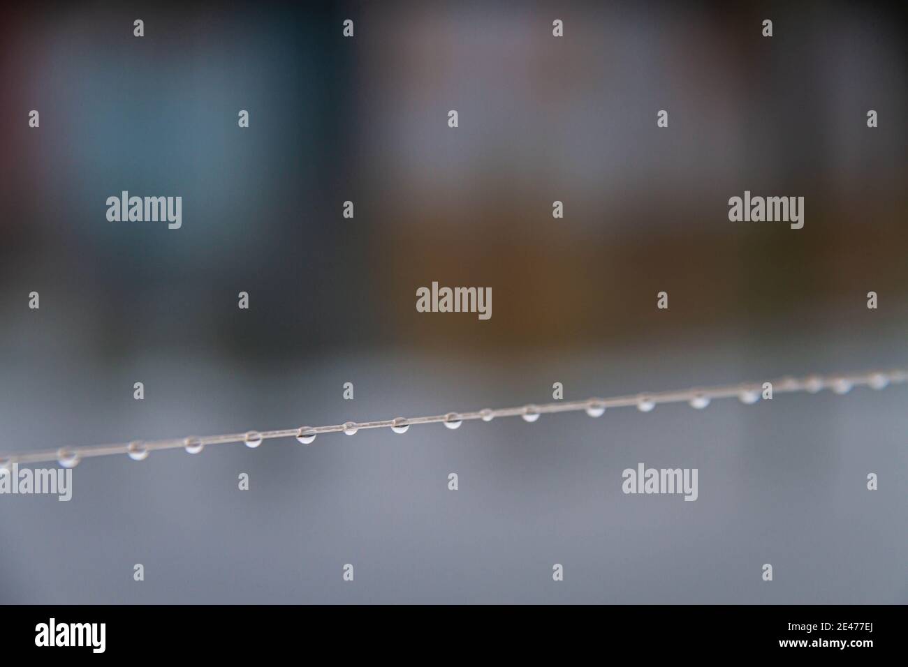 Small beads of water drops on a string fading out of focus with a muted ...