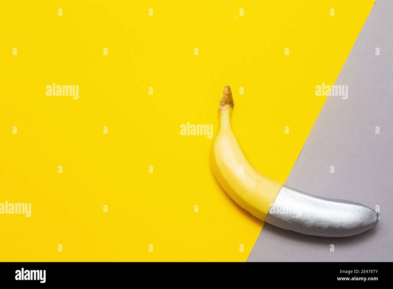 Painted silver banana on a yellow and gray background. Minimalistic ...
