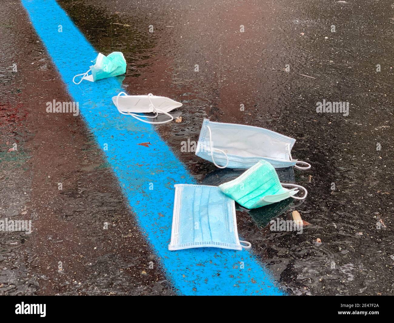 Pile of face masks thrown on the wet asphalt Stock Photo - Alamy
