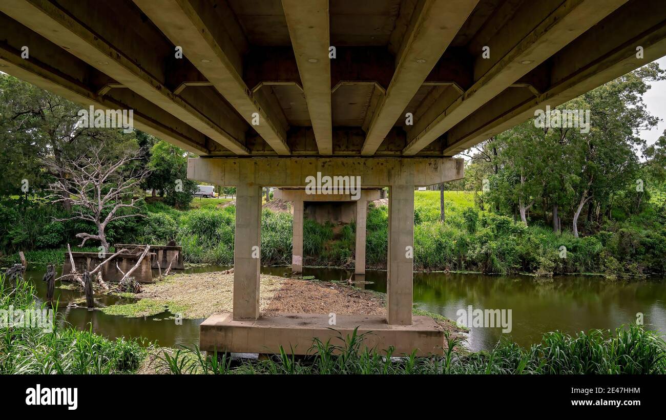 The underside of a concrete bridge over a creek Stock Photo - Alamy