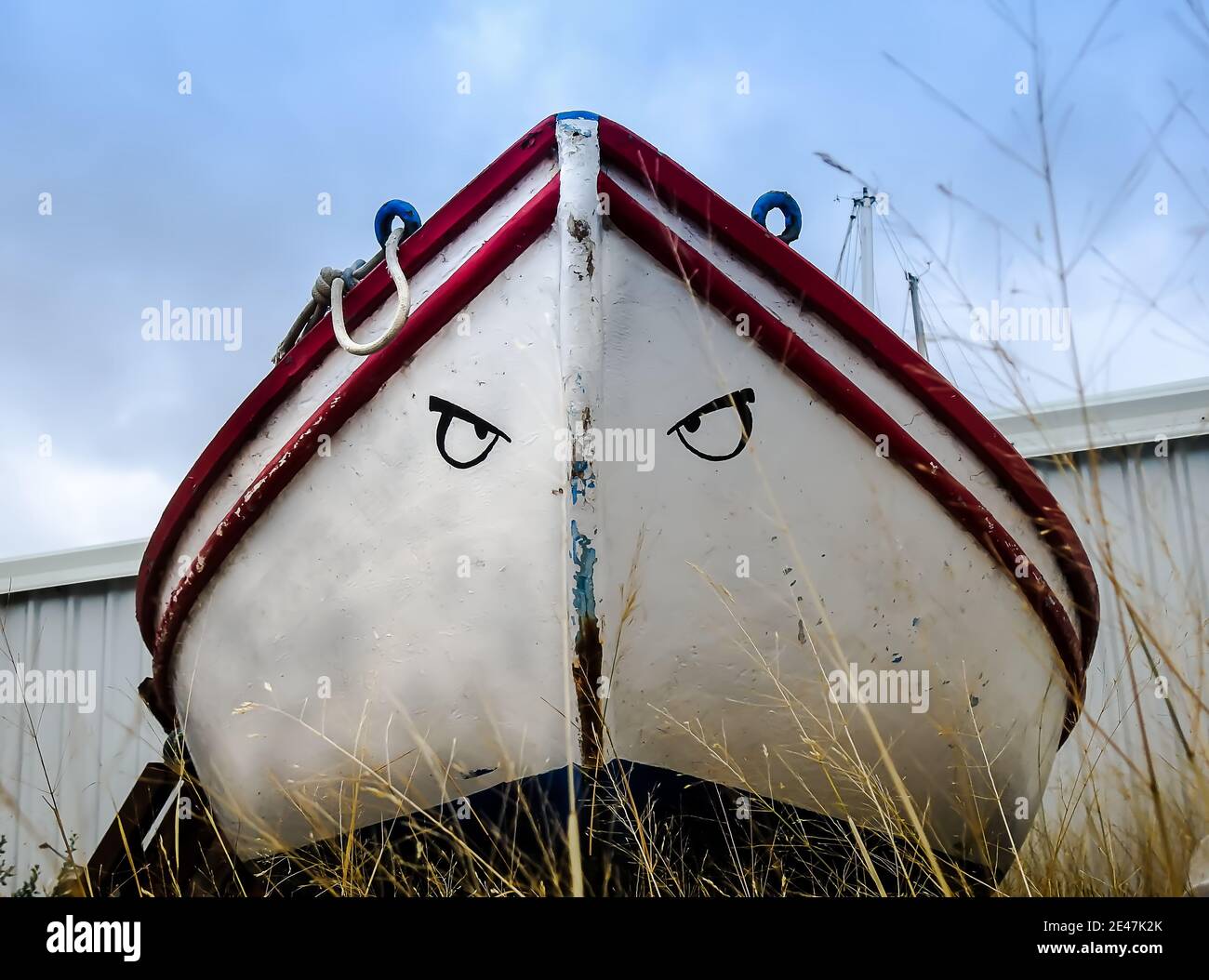 Closeup of a weathered boat with funny, angry eyes painted on it Stock ...