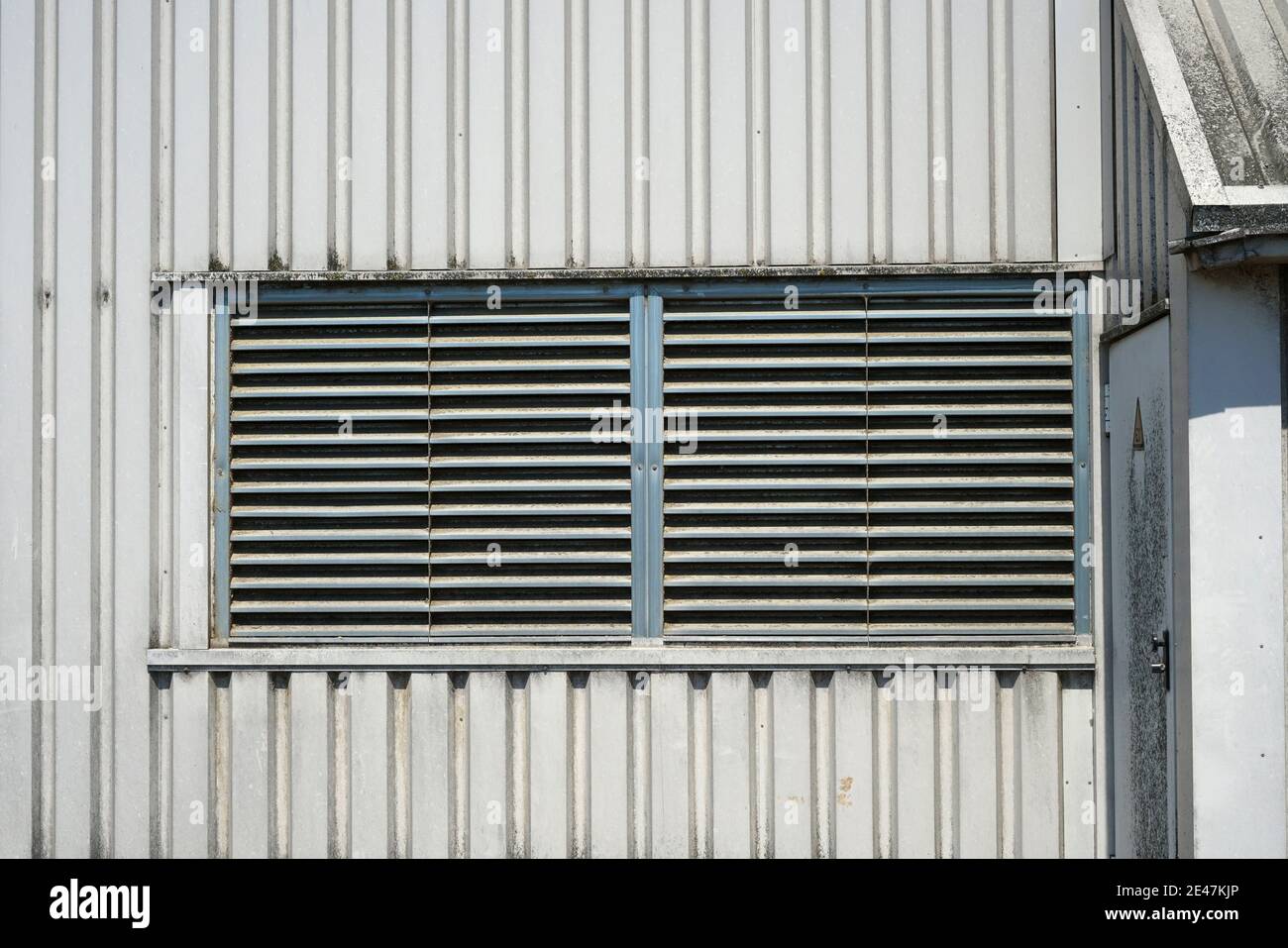 Closeup of the metallic window bar of a house with iron sheets wall ...