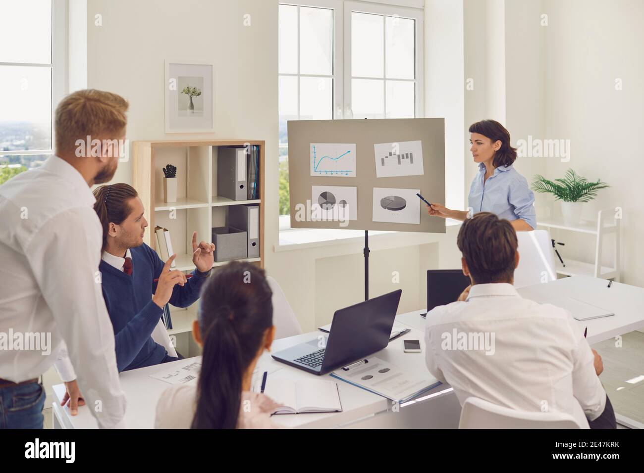 Company workers listening to sales report in corporate meeting ...
