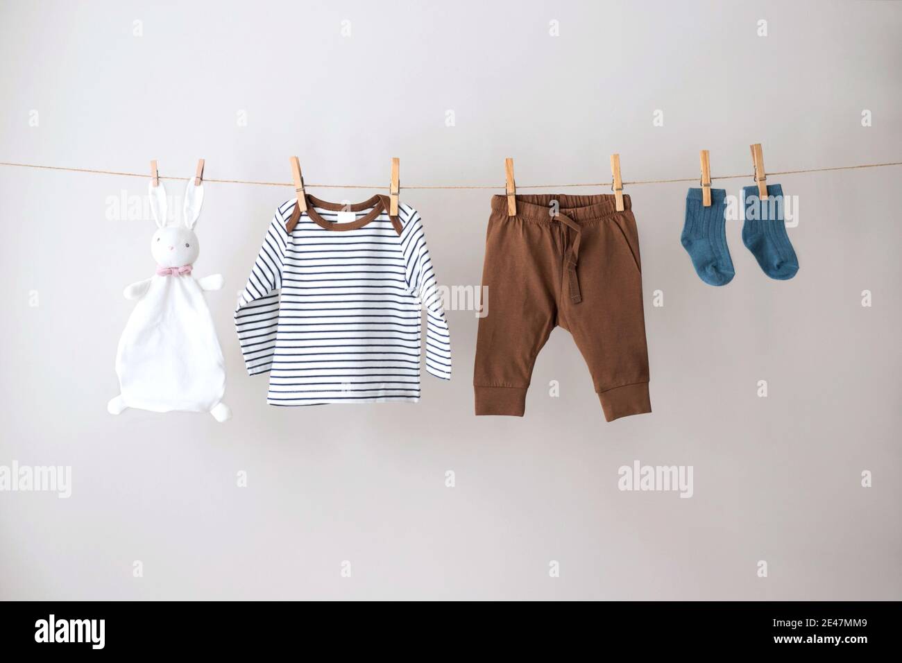 Baby clothes hanging on the rope on gray background Stock Photo - Alamy