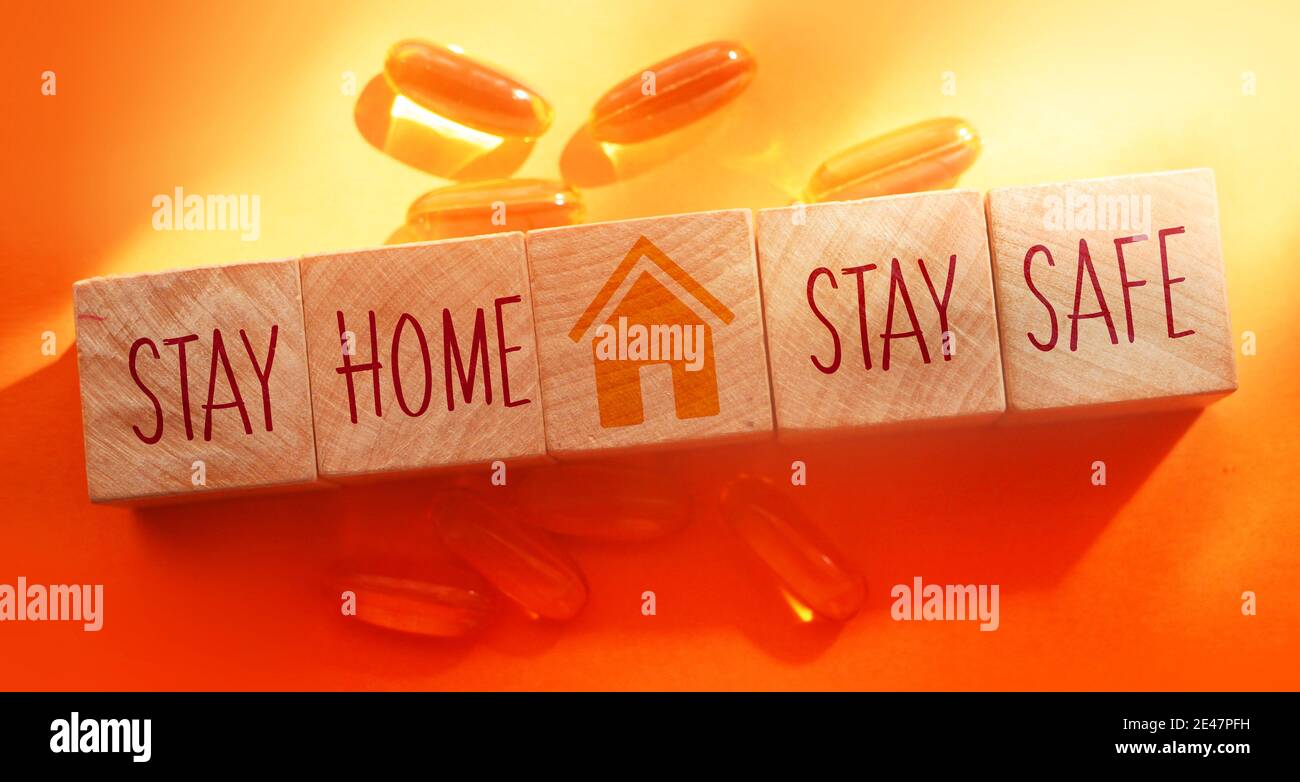 Stay Home Stay Safe text on wooden cubes and pills around on orange ... Stay Home Stay Safe text on wooden cubes and pills around on orange ...