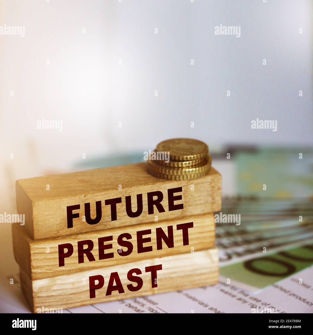Past Present Future words written on wood block. 100 Euro banknotes and ...