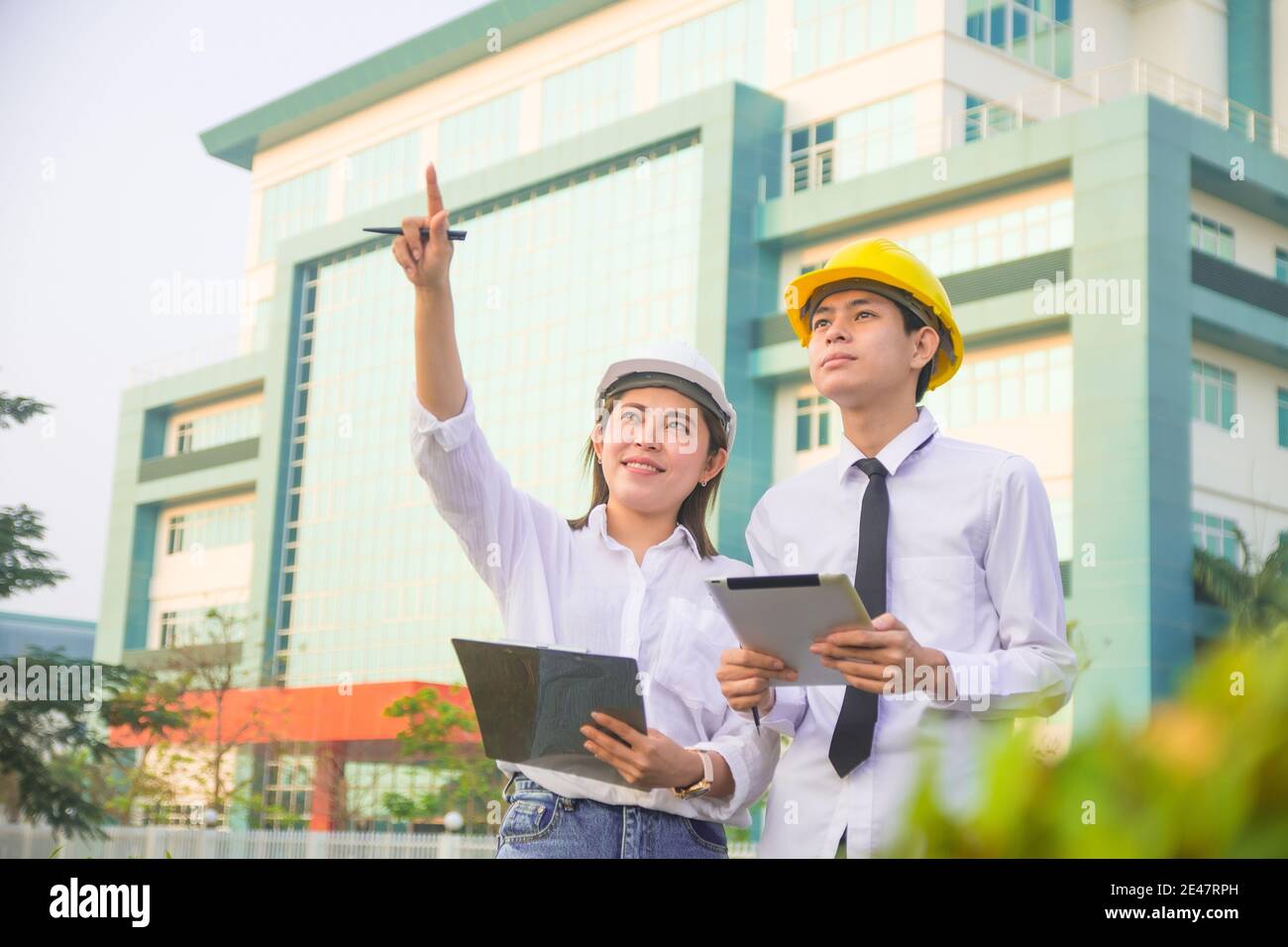 Businessman Businesswomen in hard hat use tablet talking project ...