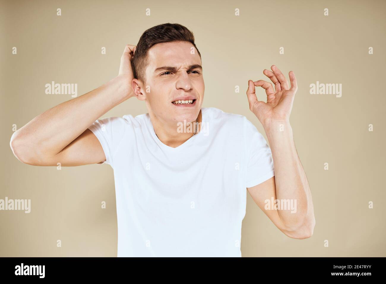 Emotional man facial expression gesture with hands white t-shirt beige ...