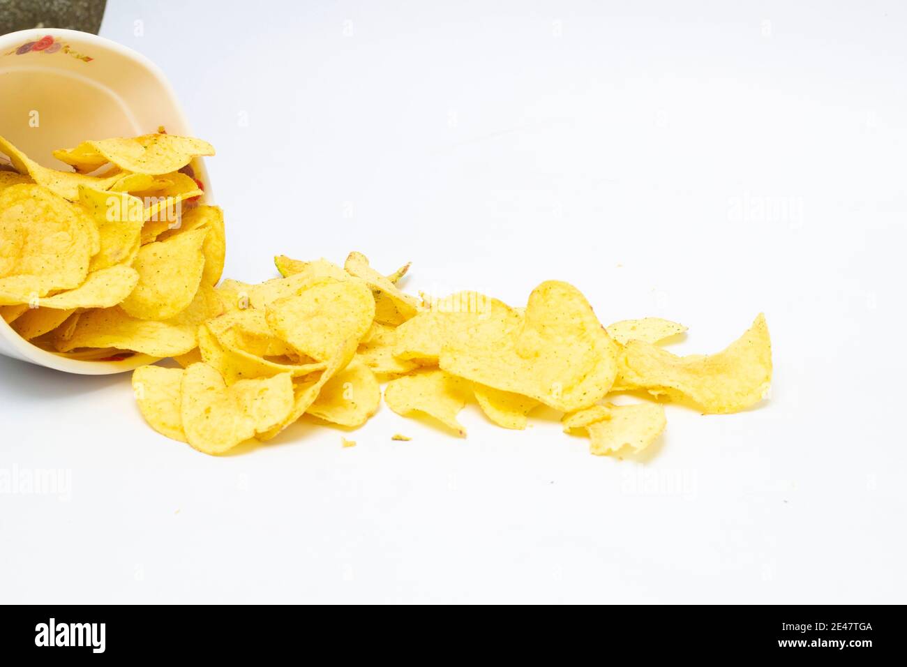 Potato chips falling into bowl isolated on white background Stock Photo ...