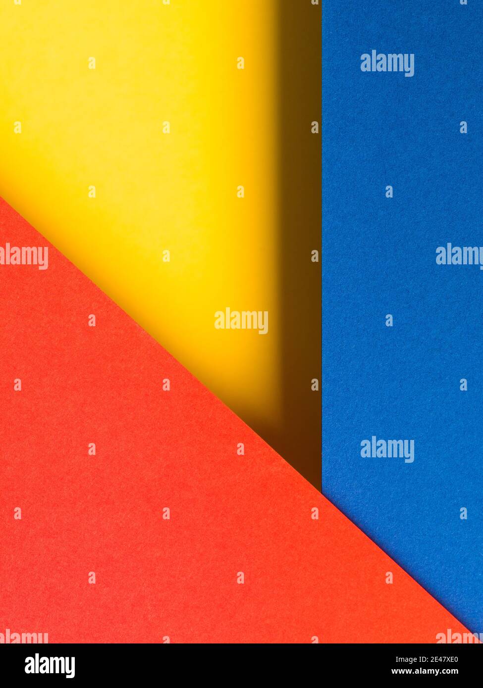 Abstract background made from yellow, red and blue paper, top view ...