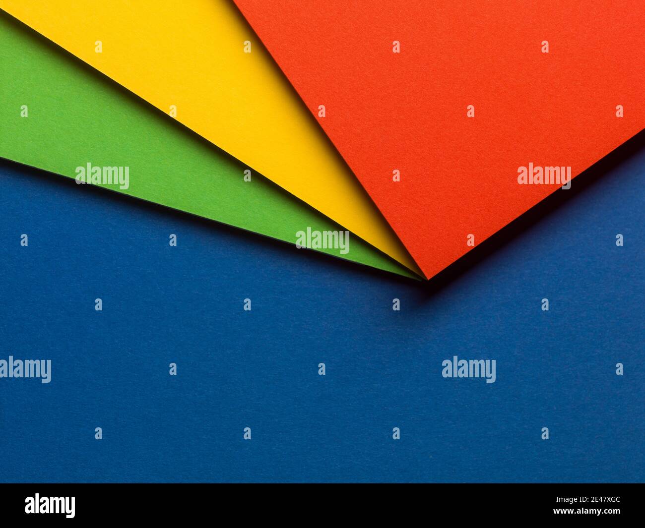 Colorful paper design with red, yellow and green on a blue background ...
