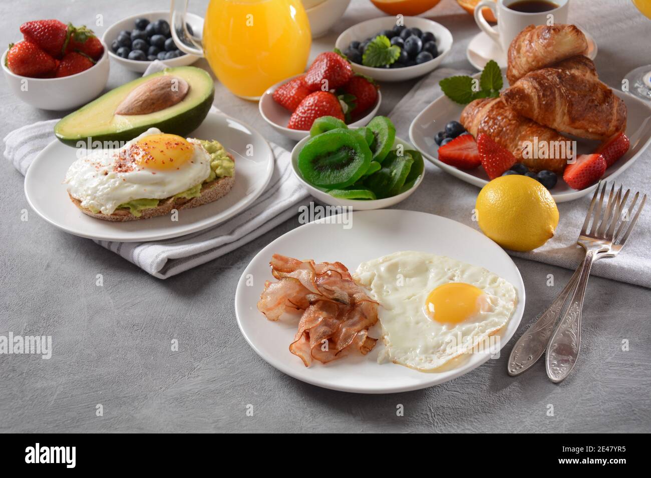Healthy breakfast. Toast with avocado and egg, bacon and eggs, fresh ...