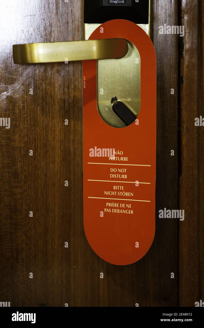 Vertical shot of the Do Not Disturb sign hanging on the hotel room door ...