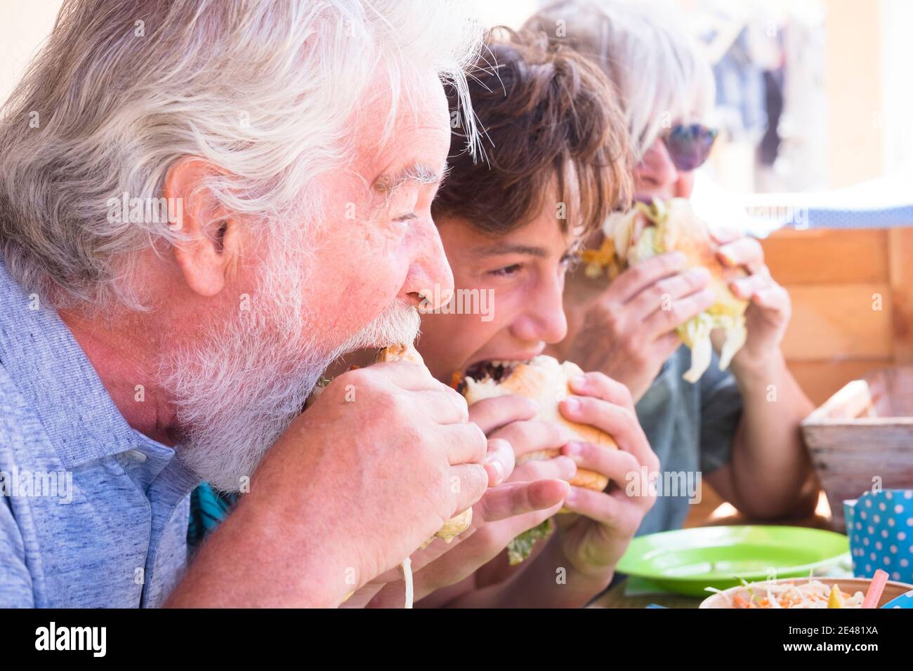 DIfferent ages group of people family eat together hamburger ...