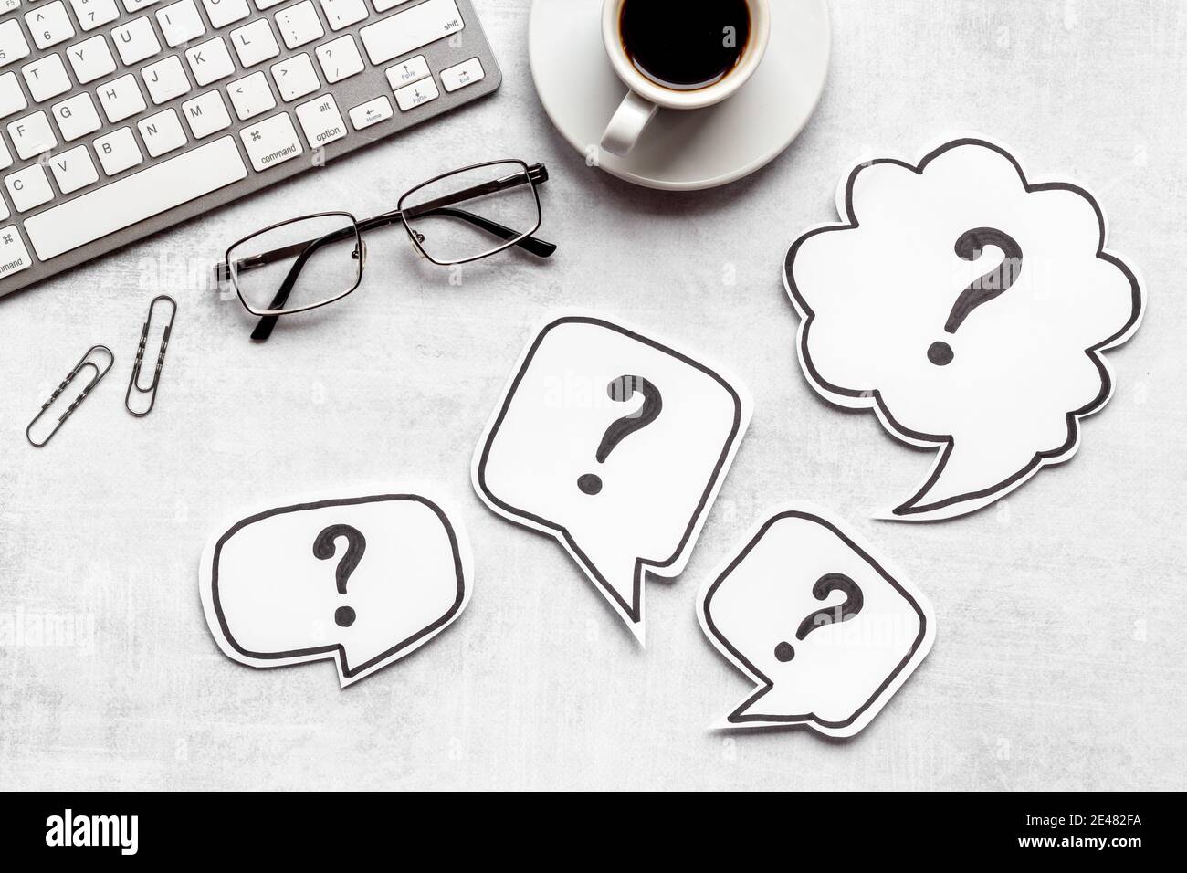 Question marks on office dest - FAQ concept. Top view Stock Photo - Alamy