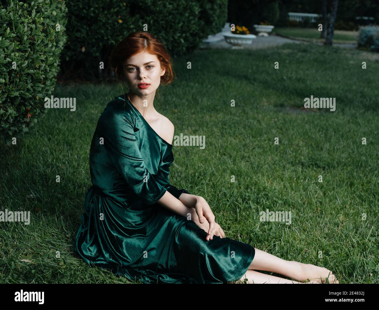 Beautiful woman green dress lawn bush luxury fresh air Stock Photo - Alamy