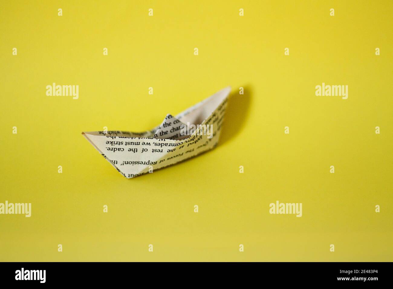 Paper boat made from a book page isolated on a yellow background Stock ...