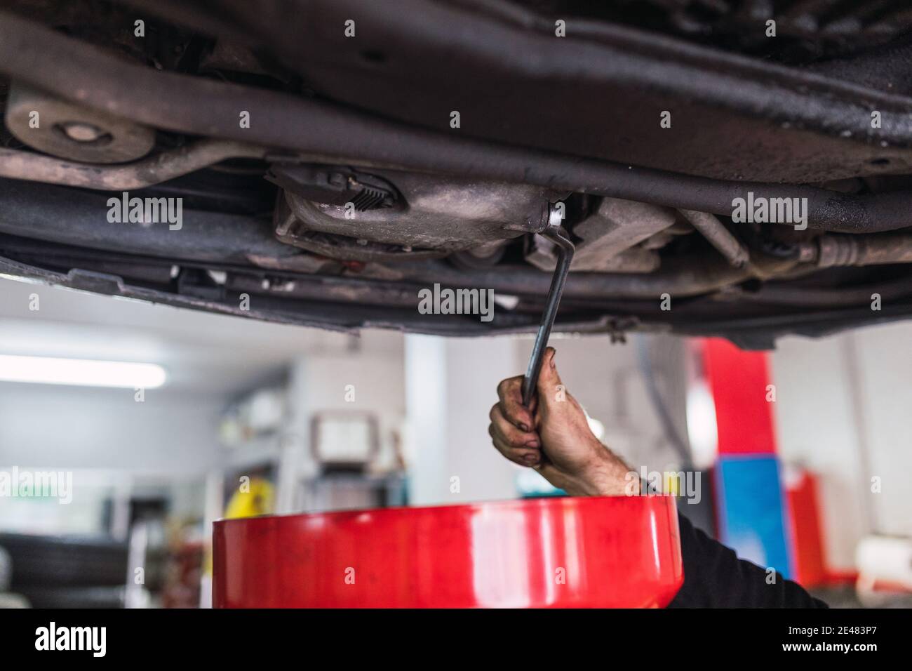 Hands of a mechanic changing the oil of the car. concept car mechanics ...