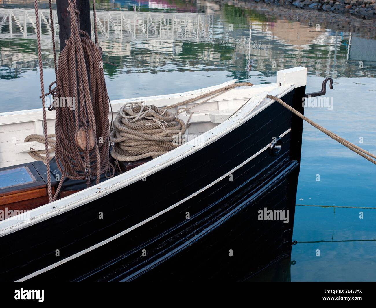 View of the bow of small open fishing boat with coiled mooring ropeiew ...