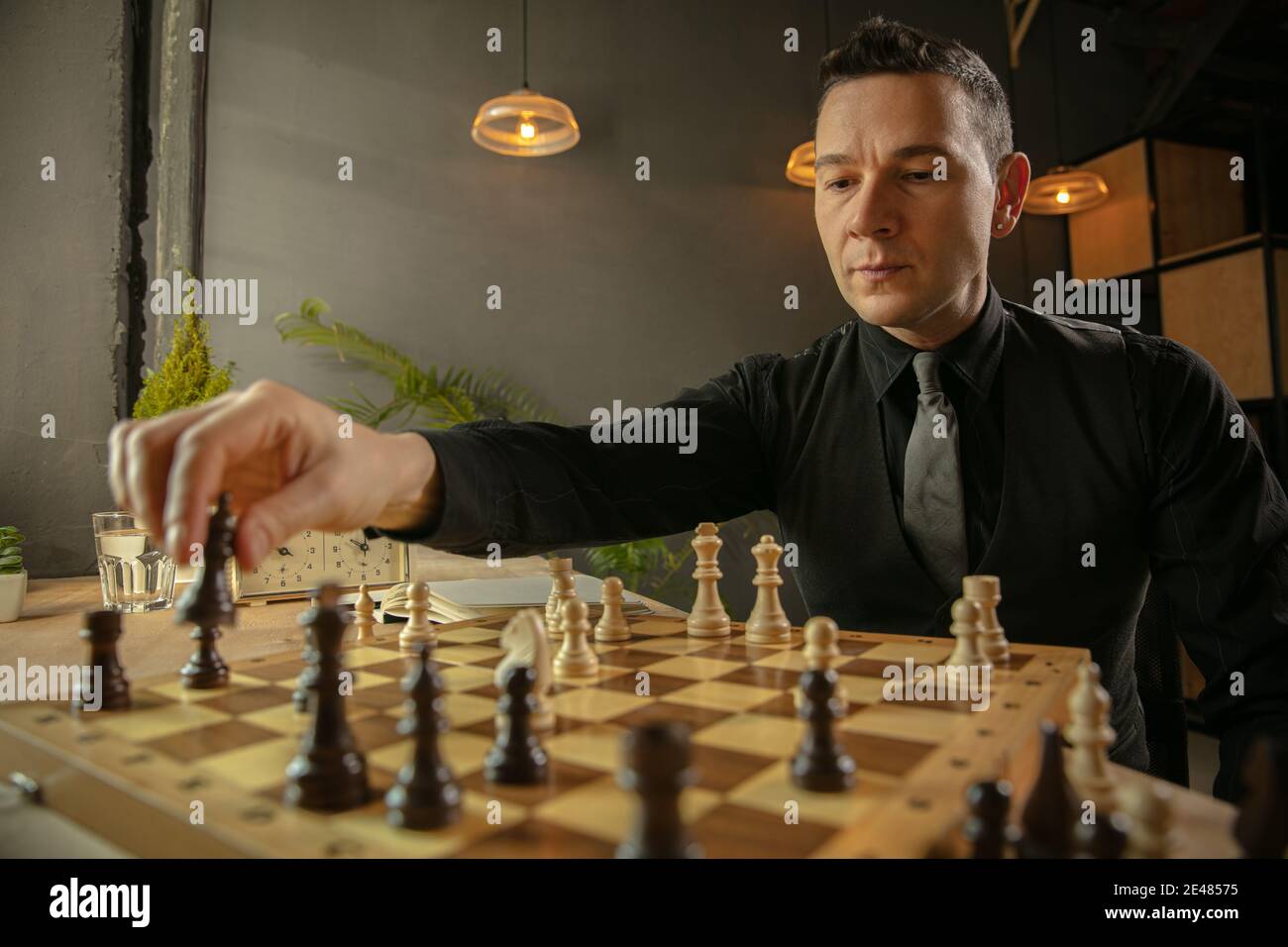 Serious man chess player sitting at home and playing chess alone Stock ...
