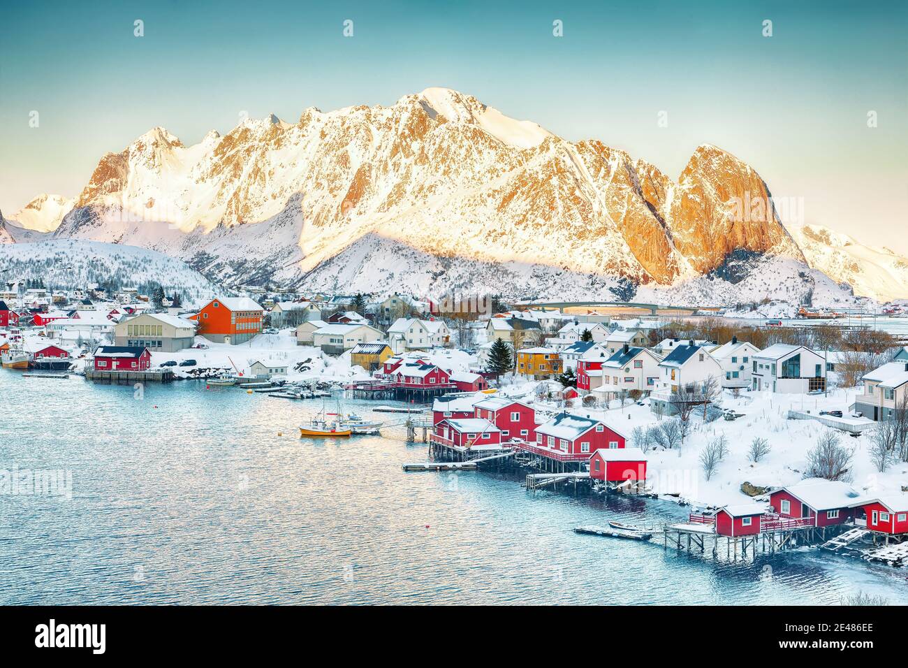Dramatic evening cityscape of Reine town. Red rorbuers on the shore of ...