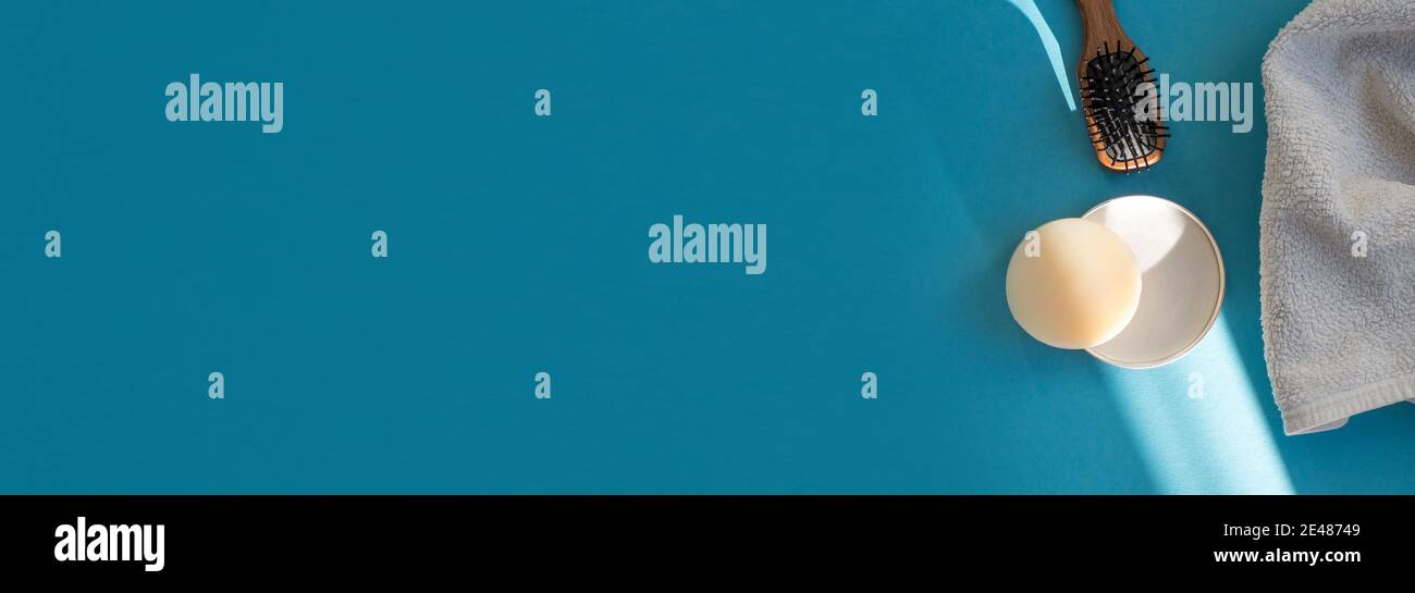 Oblong banner of a solid shampoo bar isolated on blue coloured ...