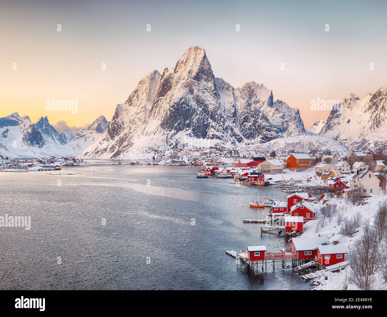 Astonishing evening cityscape of Reine town. Red rorbuers on the shore ...
