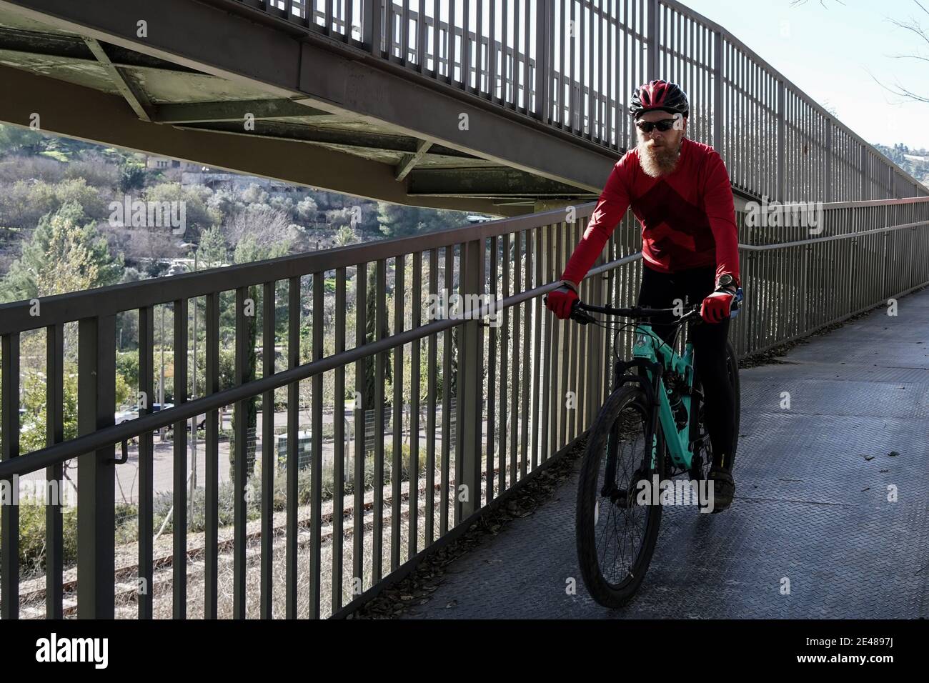 A man rides a bike on a pedestrian bridge Stock Photo - Alamy