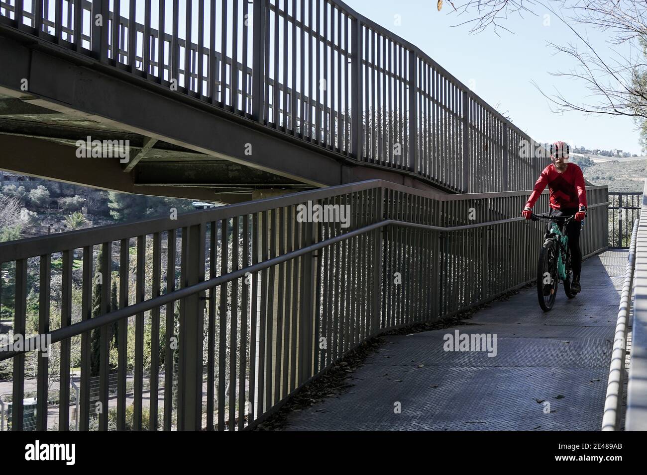 A man rides a bike on a pedestrian bridge Stock Photo - Alamy