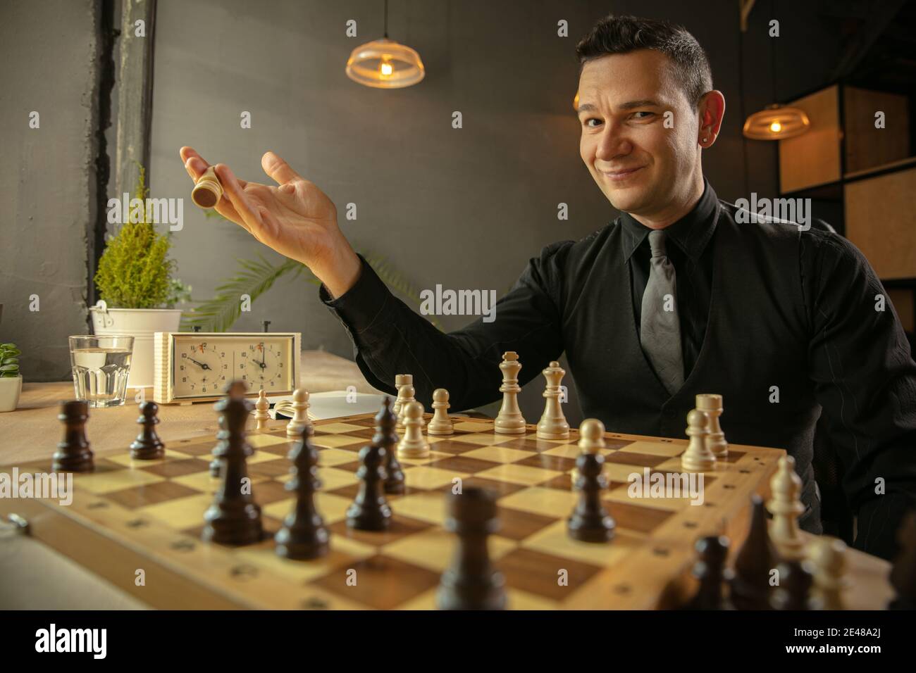 Happy Caucasian man chess player sitting at home and playing chess ...