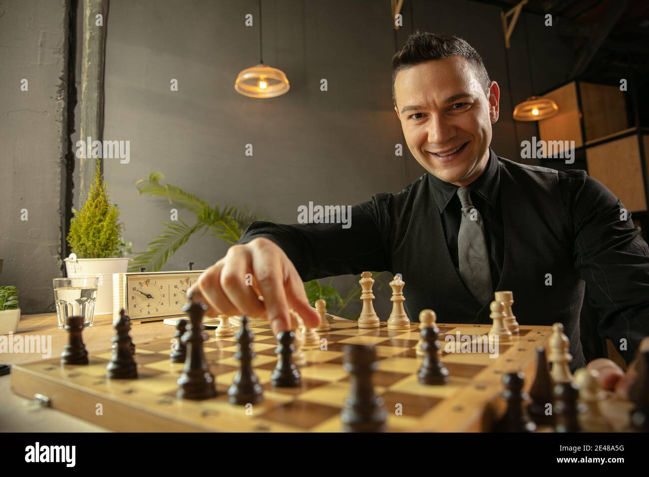 Happy Caucasian man chess player sitting at home and playing chess ...