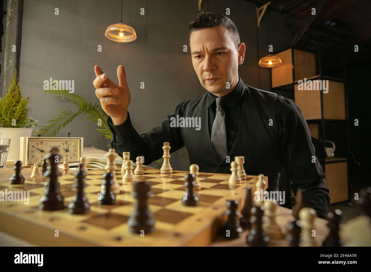 Serious man chess player sitting at home and playing chess alone Stock ...