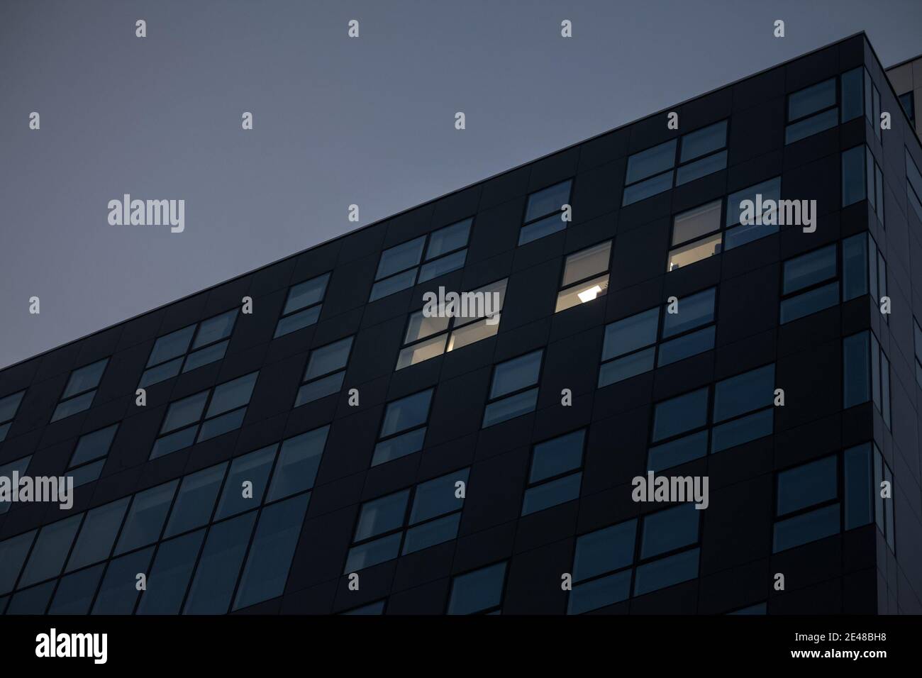 Facade of a business district building, a high rise, at night, in the ...