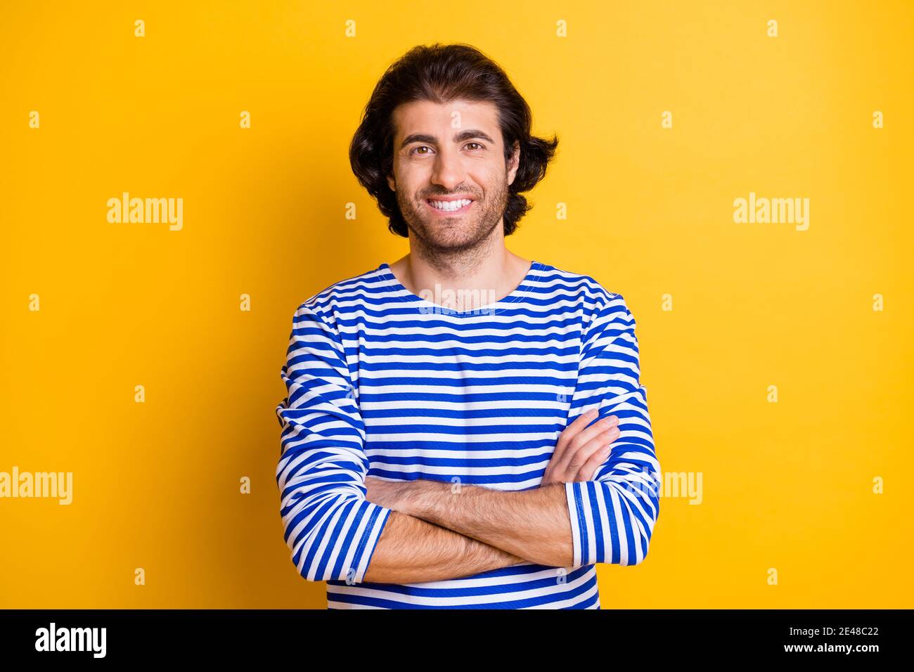 Photo of attractive young middle eastern man look in camera cross hands ...