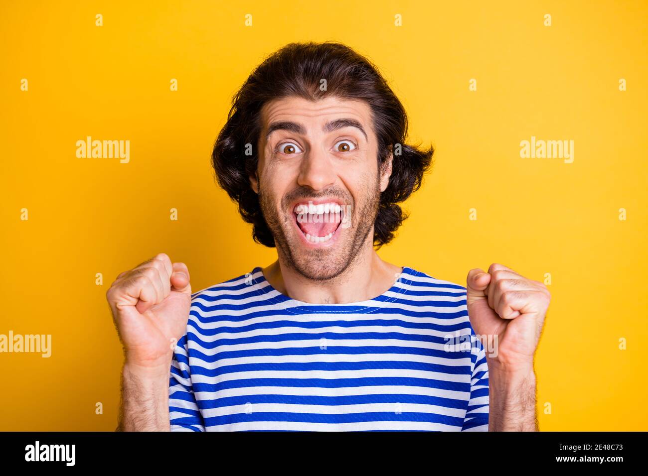 Portrait of ecstatic crazy middle eastern man scream raise fists wear ...